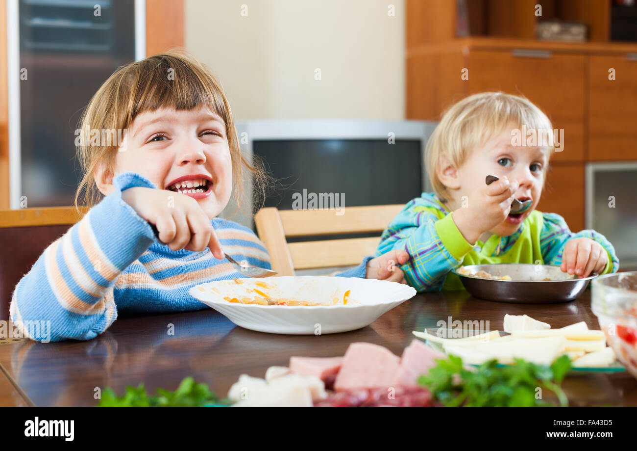 happy children eating food at wooden table Stock Photo - Alamy