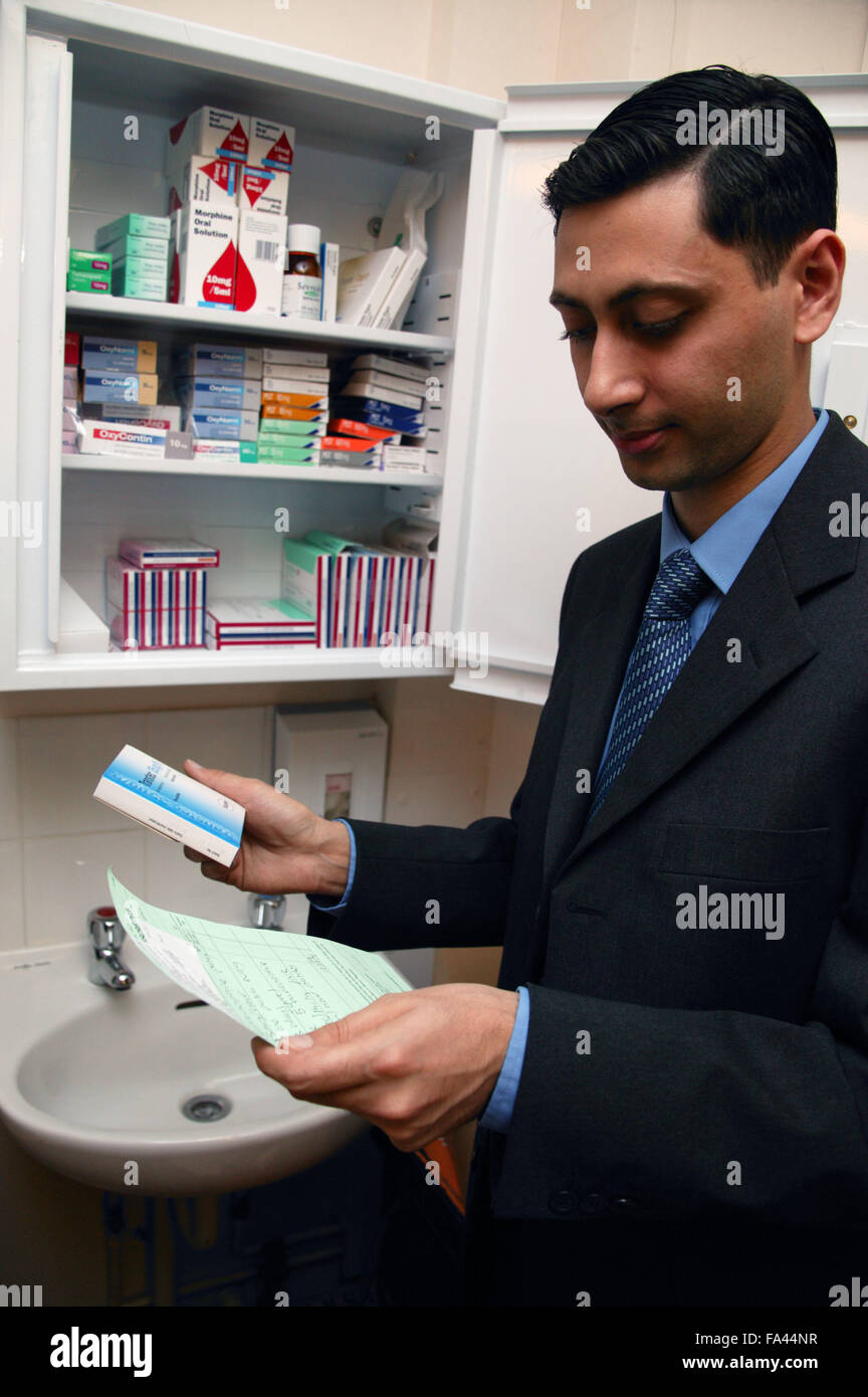 Pharmacist obtaining pain killer from controlled drugs cabinet Stock ...
