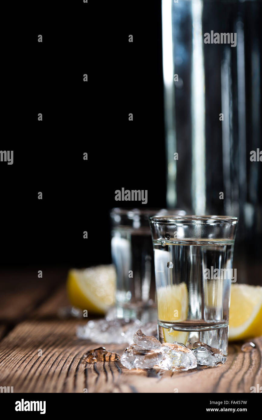 Vodka on the rocks (on an old wooden table) as detailed close-up shot ...