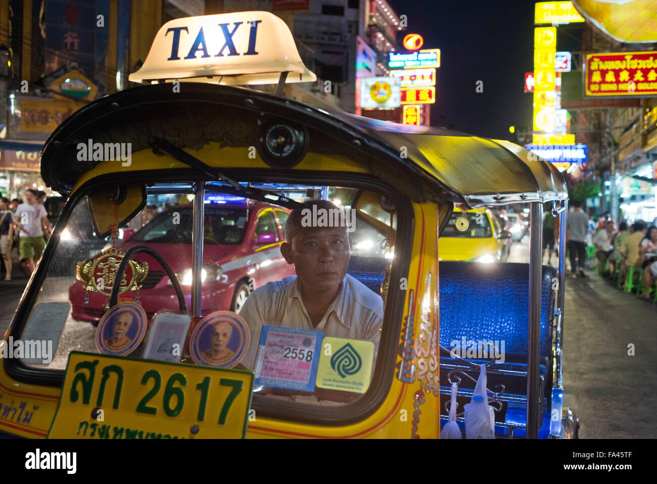 Tuk tuk taxi in the street. View down Thanon Yaowarat road at night in central Chinatown ...