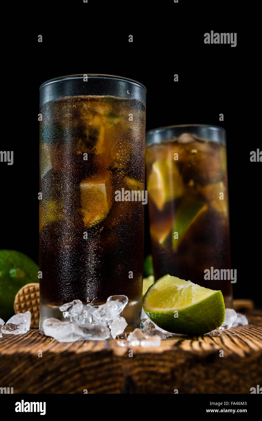 Cuba Libre longdrink with pieces of fresh lime and crushed ice on ...