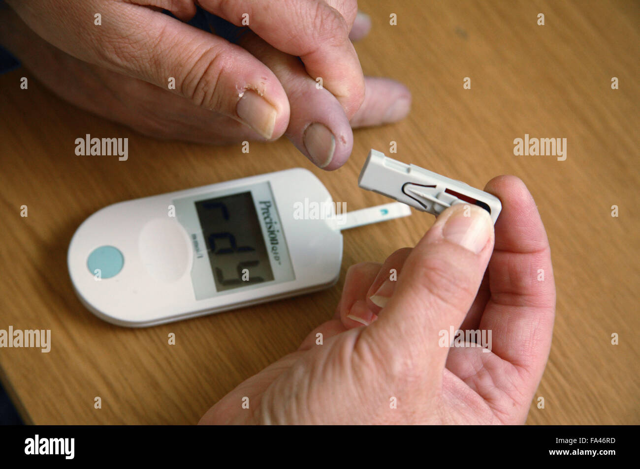 Blood glucose meter being placed on finger of diabetic patient to check ...