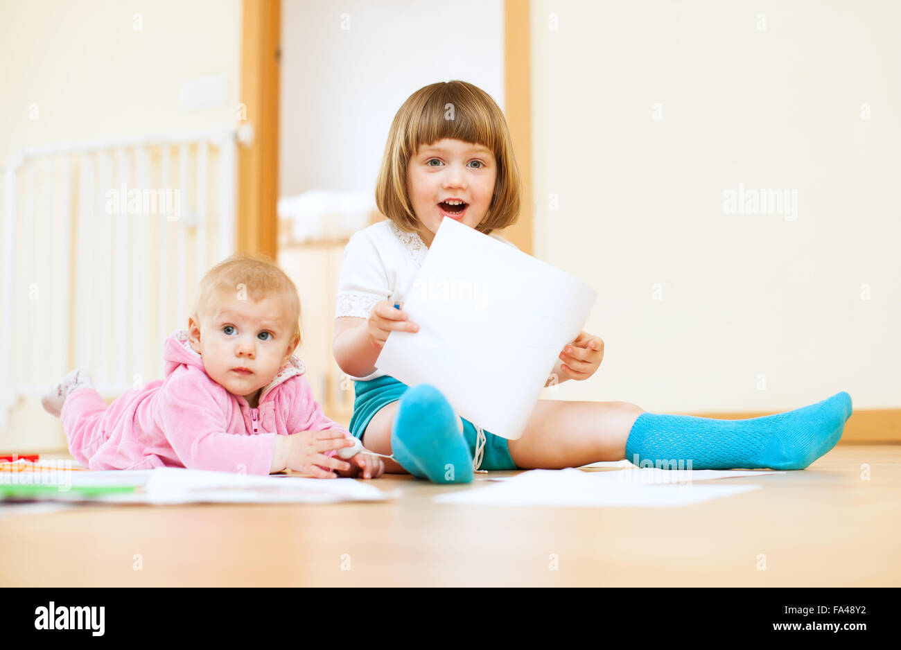 Two adorable siblings with paper in home interior Stock Photo - Alamy