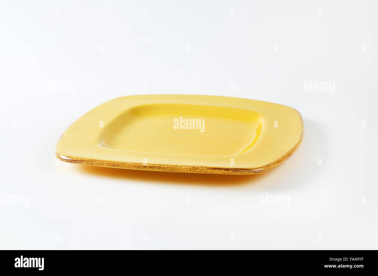 yellow square plate on white background Stock Photo - Alamy