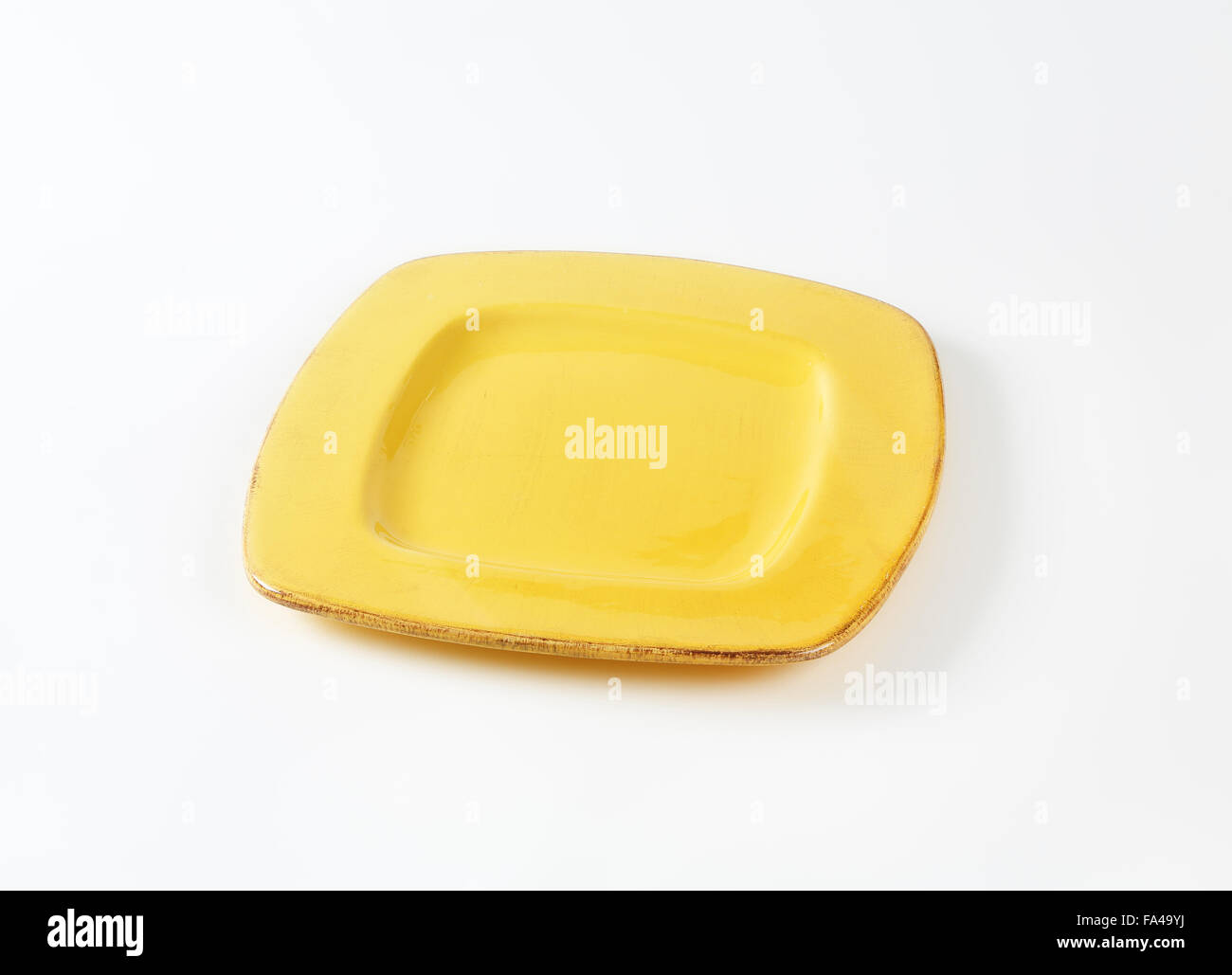 yellow square plate on white background Stock Photo - Alamy