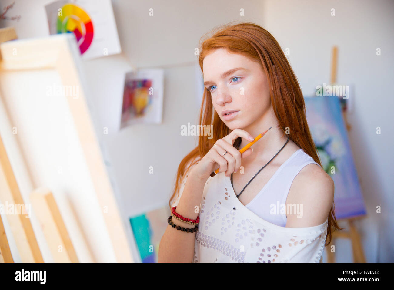 Thoughtful pretty young redhead woman artist thinking and making ...