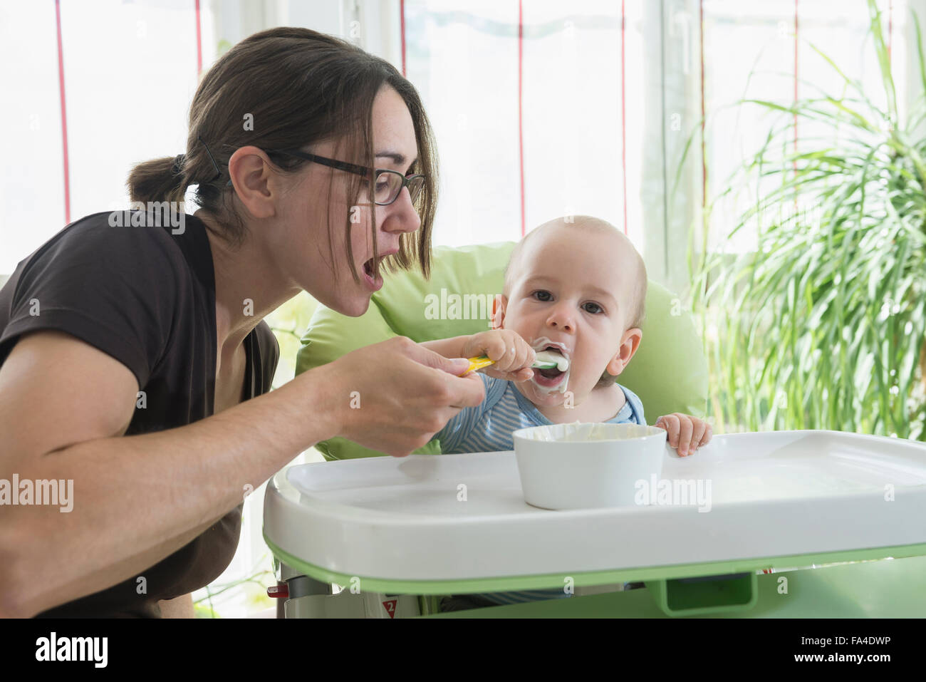 Mother feeding baby food to her baby boy with spoon, Munich, Bavaria ...