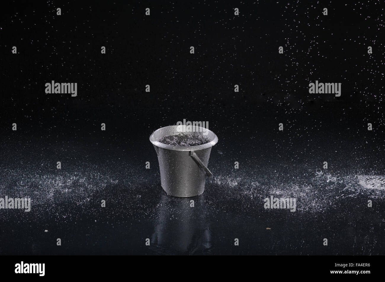 Bucket with water drops on dark background Stock Photo - Alamy