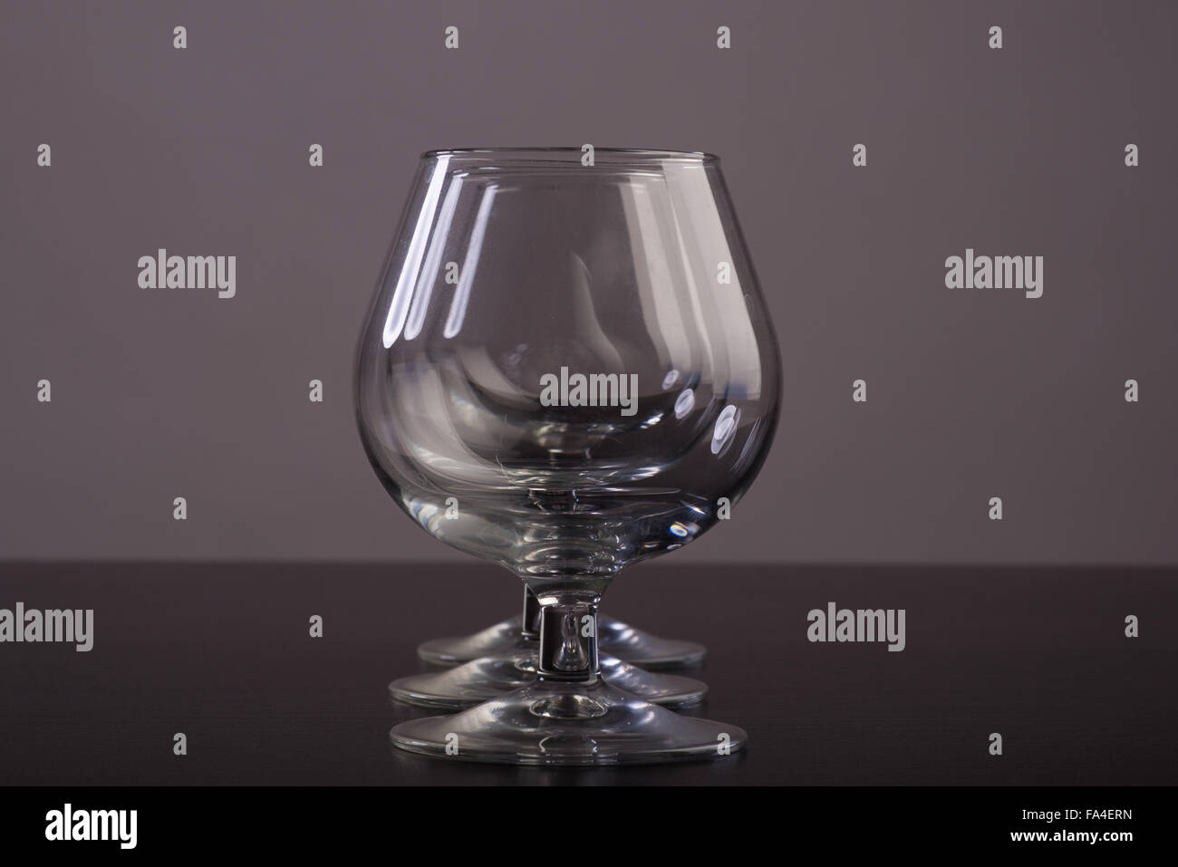 Three Empty glasses with reflections on grey background Stock Photo - Alamy