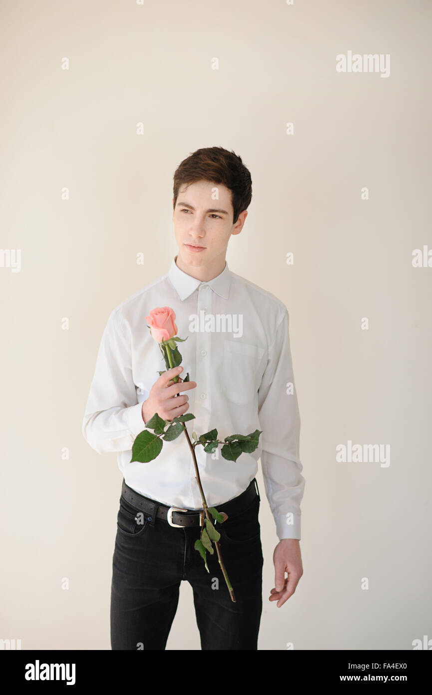 Handsome young man with single pink rose Stock Photo - Alamy