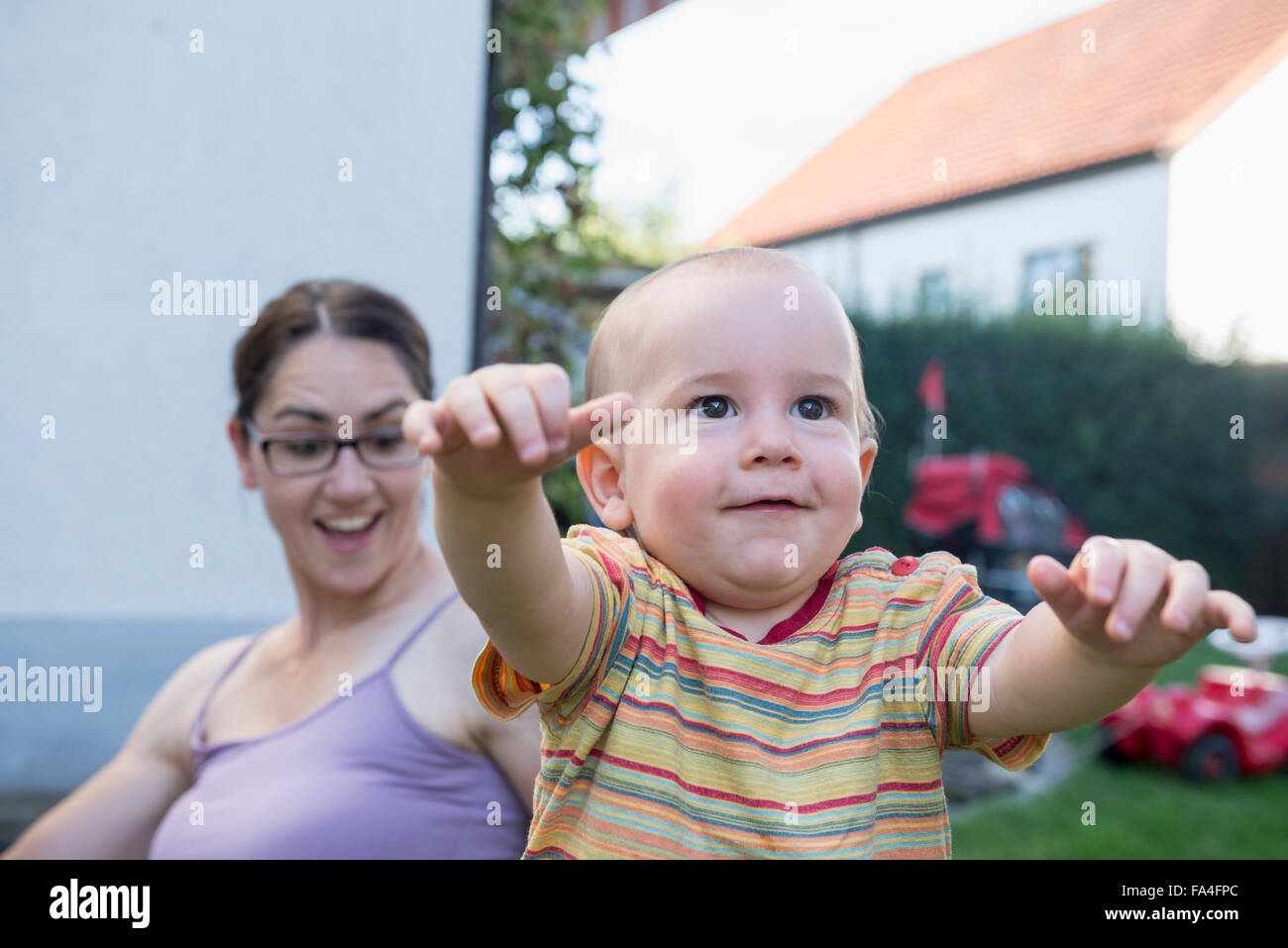 Mother is amazed about her baby son's on first steps, Munich, Bavaria ...