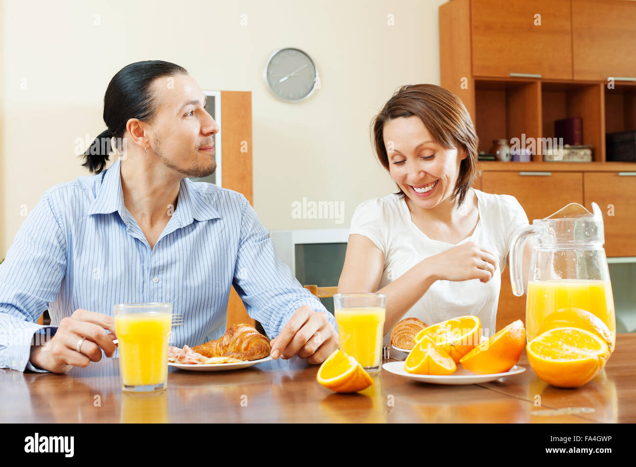 Happy couple talking over breakfast at home Stock Photo - Alamy