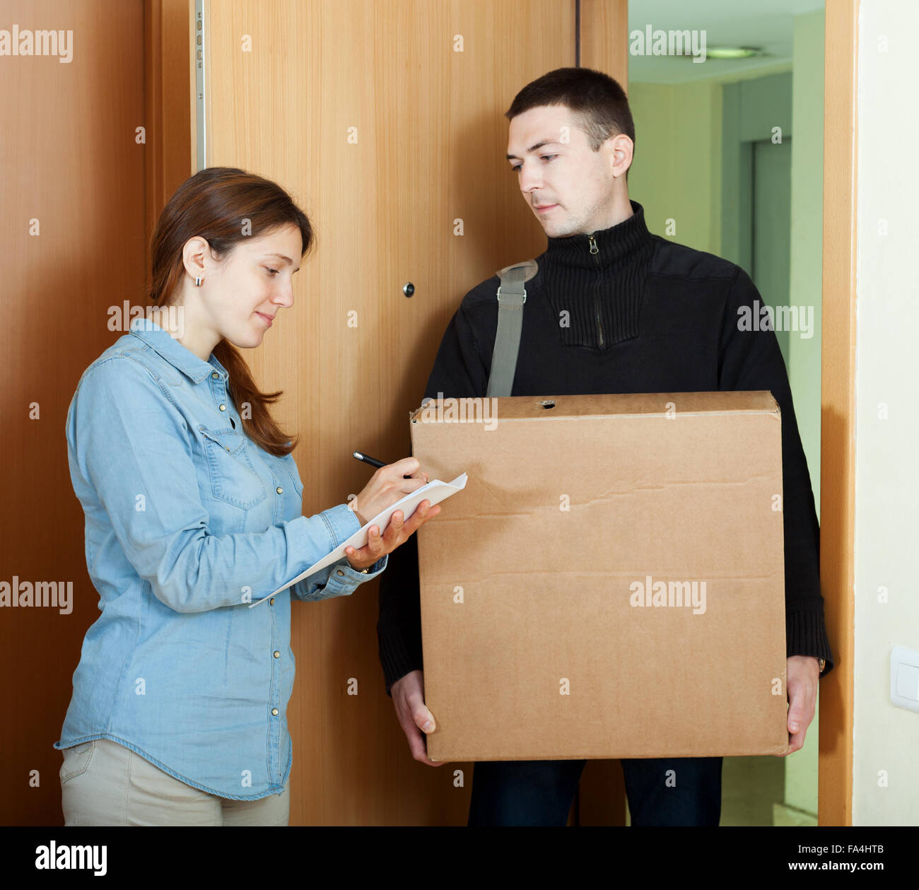 Postman brought a parcel to woman Stock Photo - Alamy