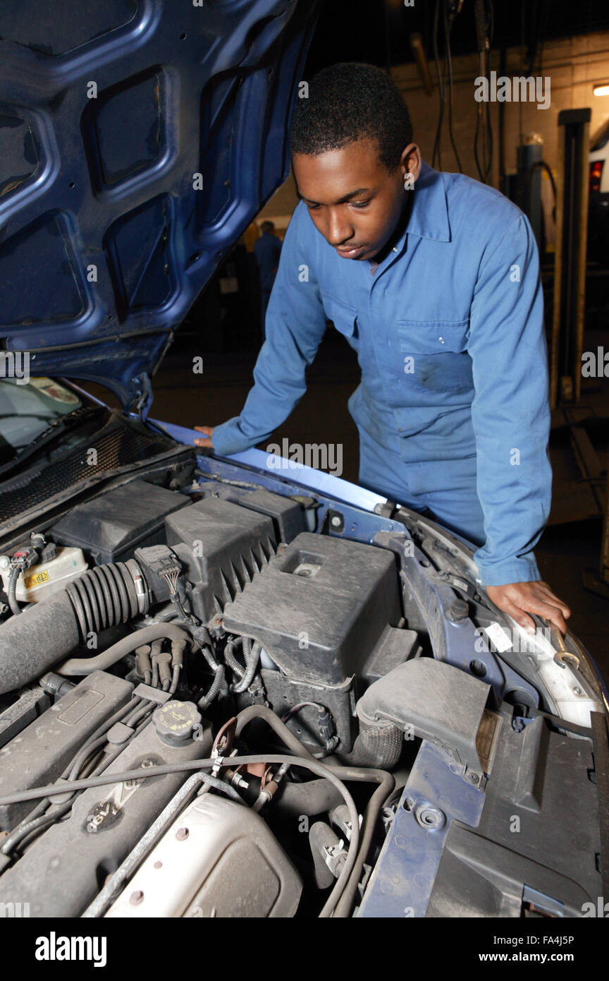 Mechanic looking into the bonnet of a car Stock Photo - Alamy