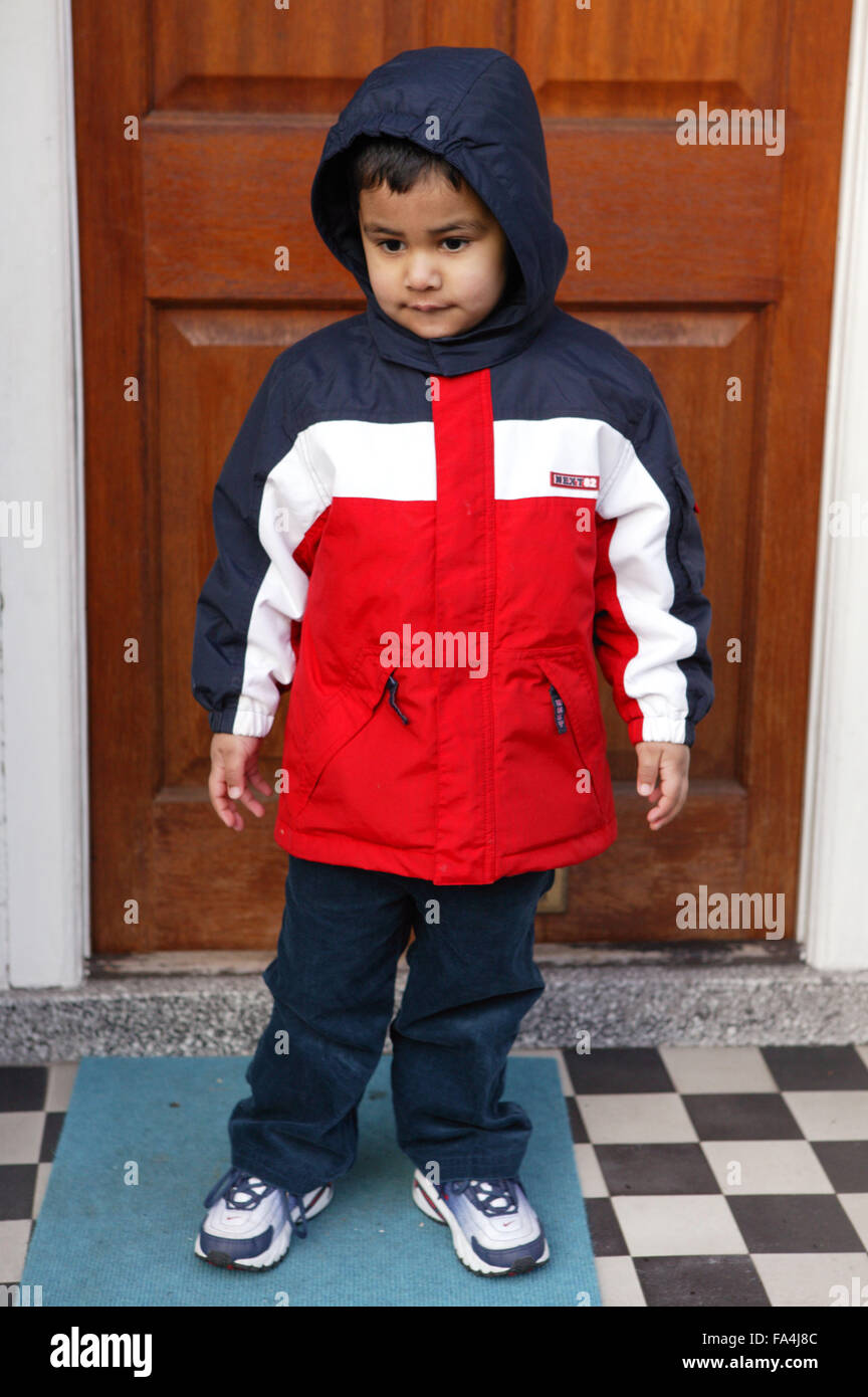 Young boy standing outside the front door of his house Stock Photo - Alamy