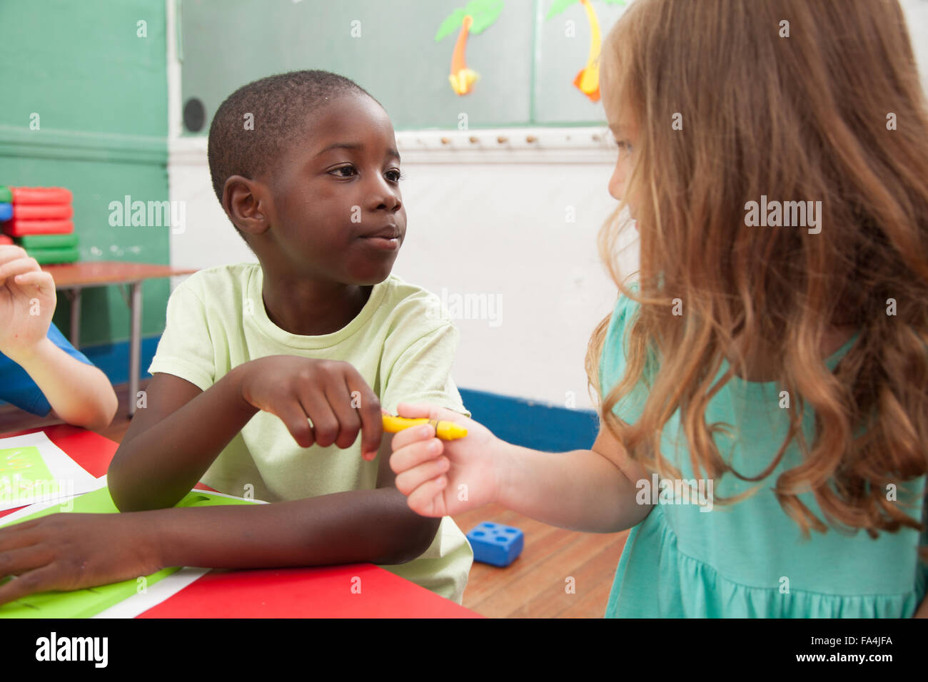 Boy giving the crayon to a girl Stock Photo - Alamy