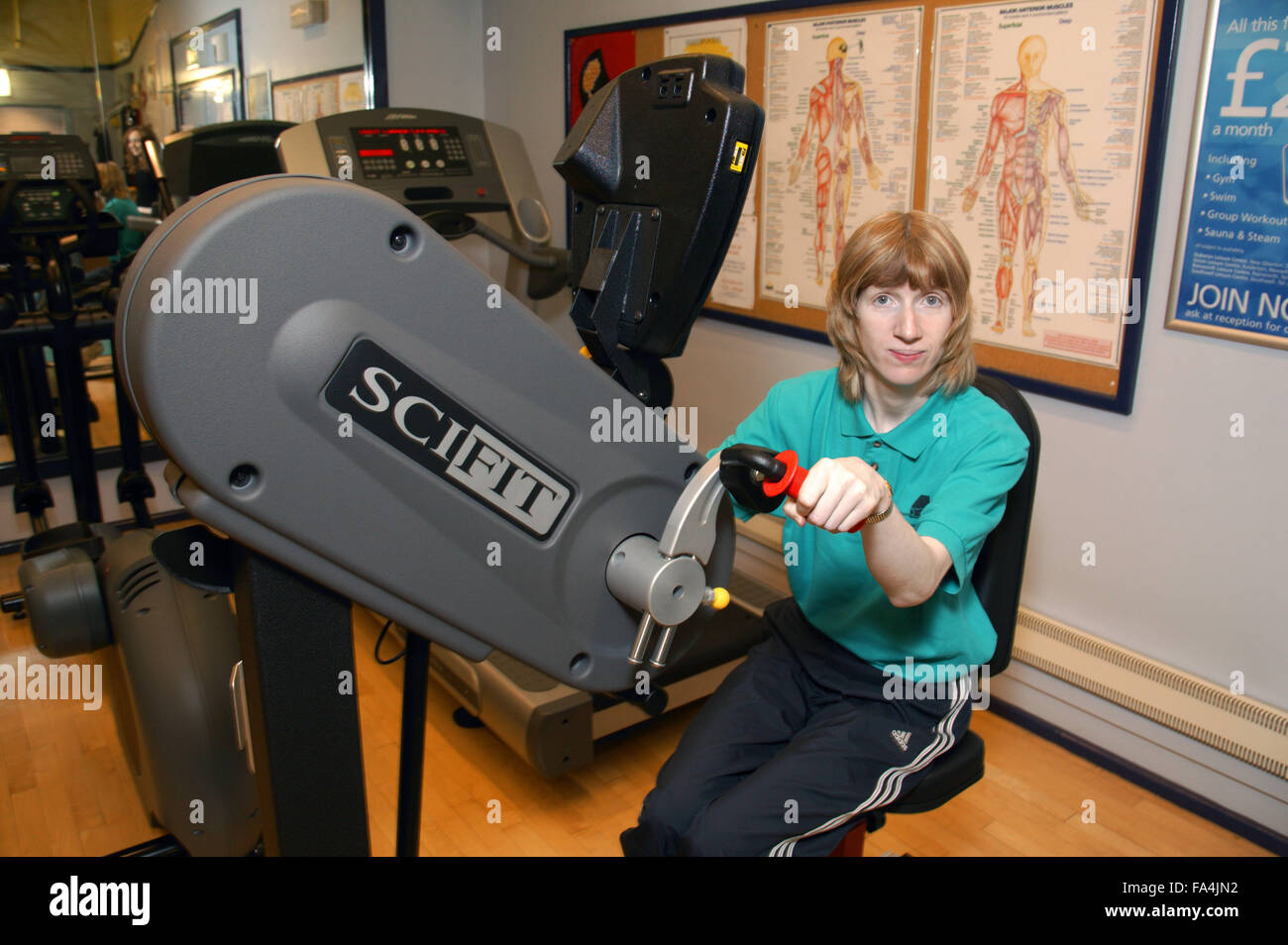 Woman using upper body ergometer at an inclusive fitness gym Stock ...