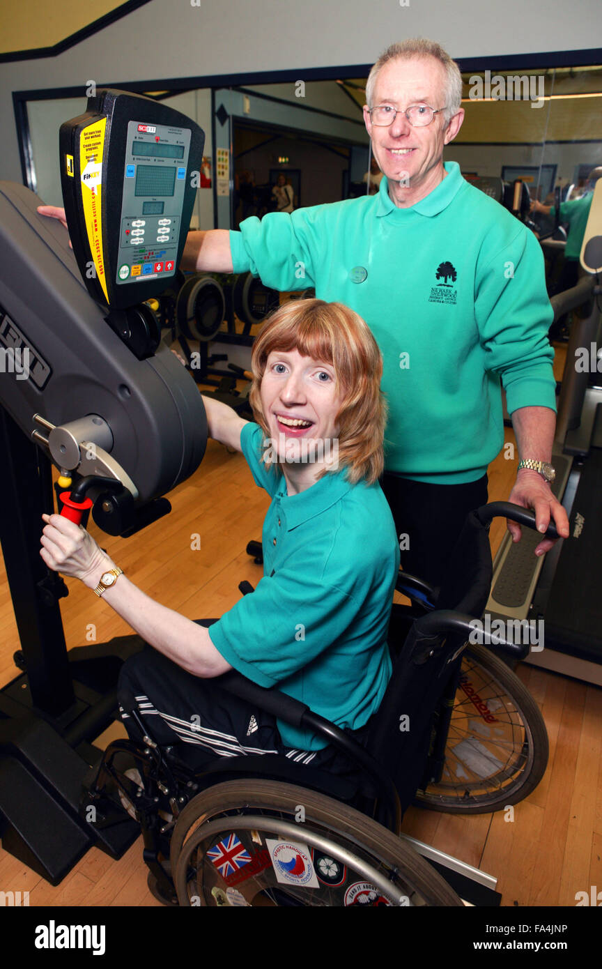 Woman with instructor using upper body ergometer at an inclusive ...