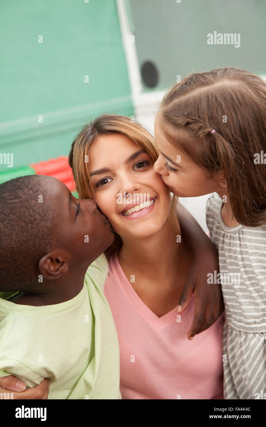 Pupils giving a kiss to their teacher Stock Photo - Alamy