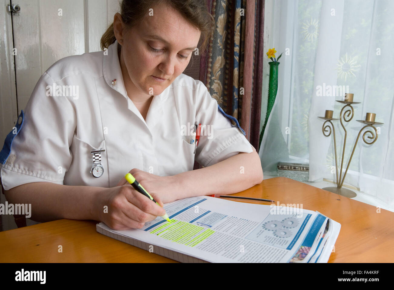 Nurse working on paperwork at home Stock Photo - Alamy