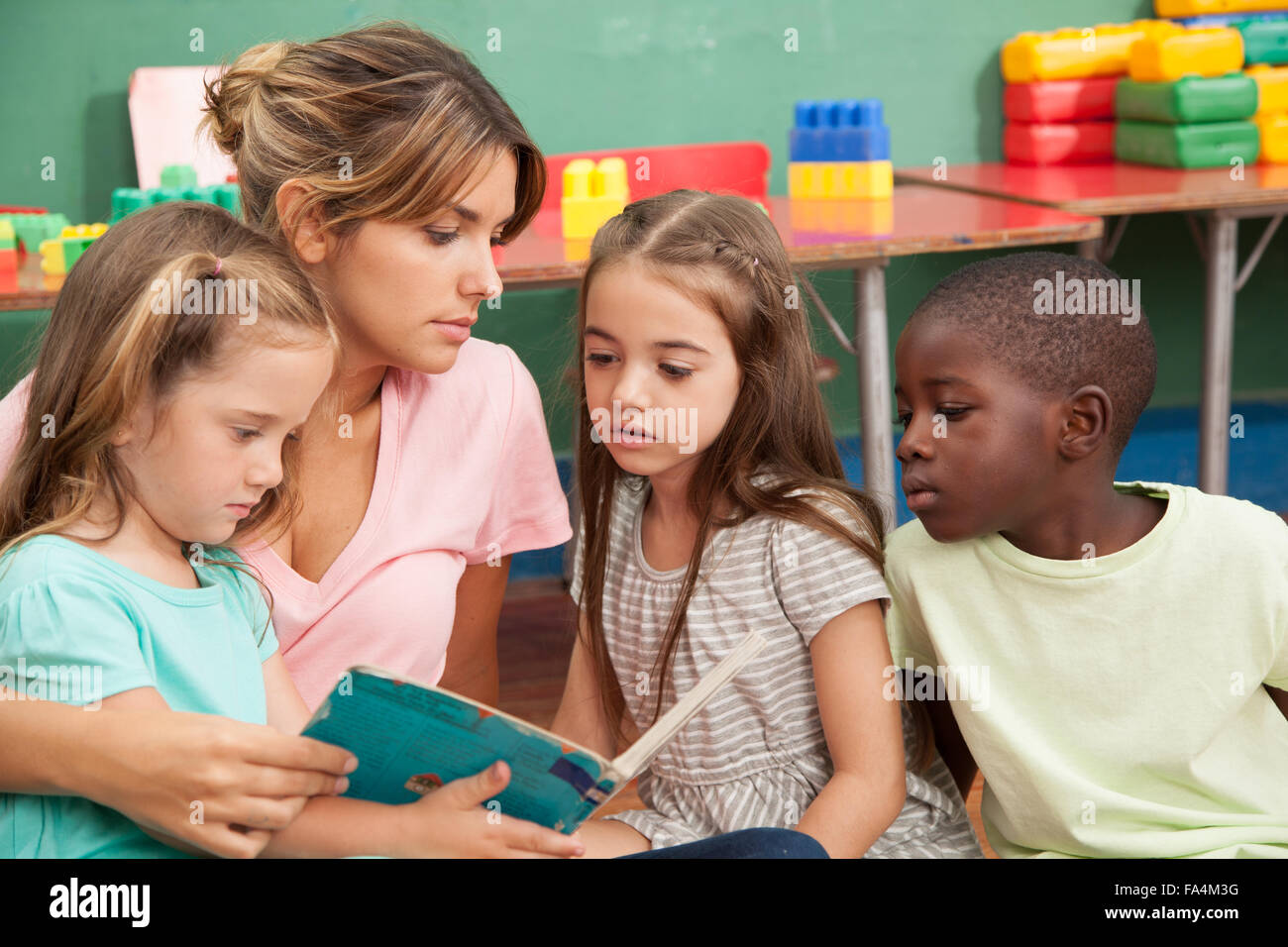 Teacher reading a book to her pupils Stock Photo - Alamy