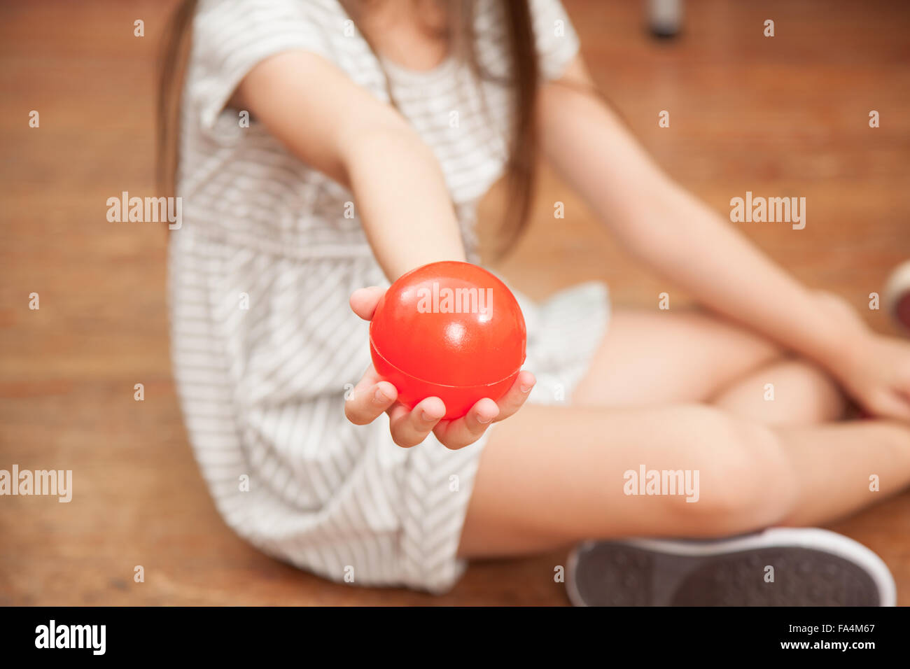 Girl showing a red ball Stock Photo - Alamy