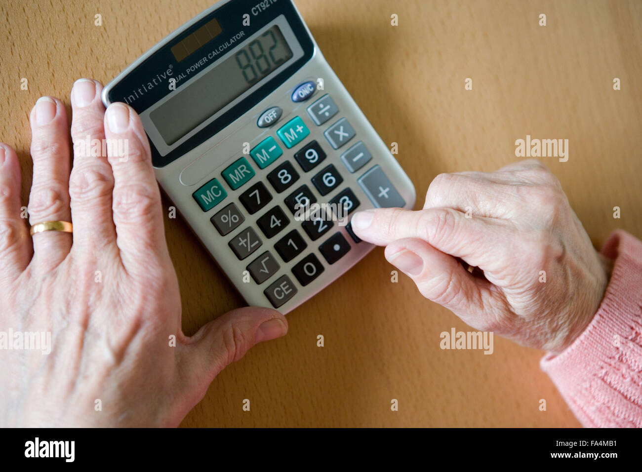 Older woman doing a calculation on a calculator Stock Photo - Alamy