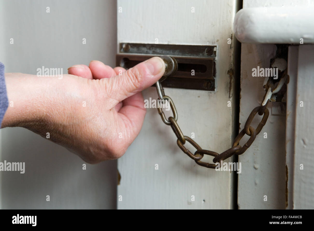Safety chain being slotted into catch to keep door secure Stock Photo ...