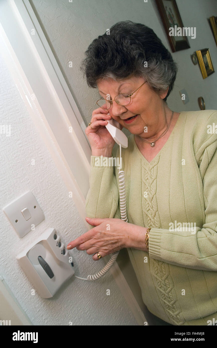 Woman speaking into an entry phone to see who is at the door Stock ...