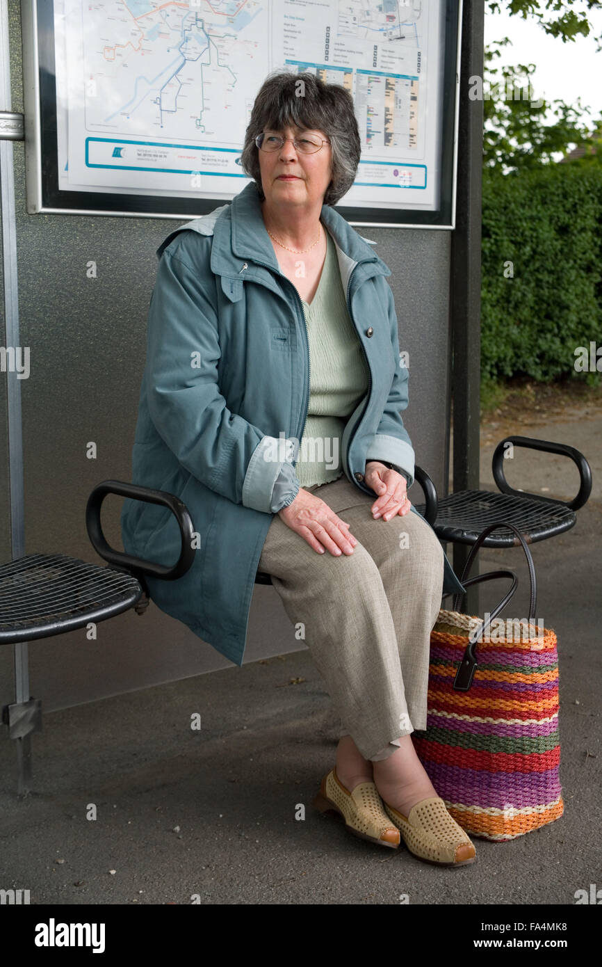 Elderly woman sitting bus stop hi-res stock photography and images - Alamy