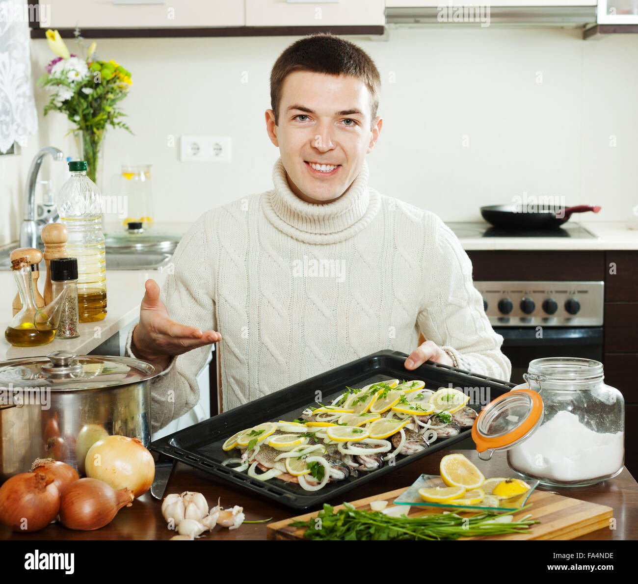 Smiling guy cooking trout fish with lemon in roasting pan Stock Photo ...