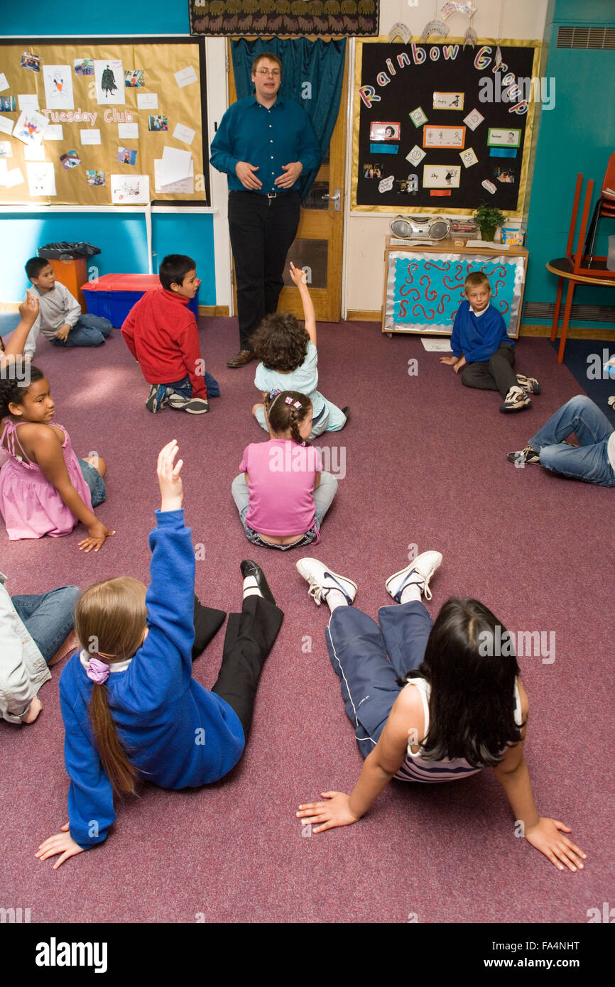Teacher standing at front of classroom talking to group of school ...