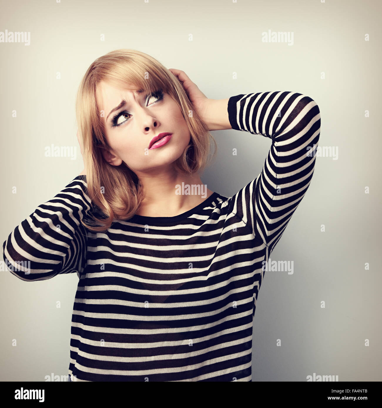 Annoyed unhappy thinking young woman looking up. Toned color portrait ...
