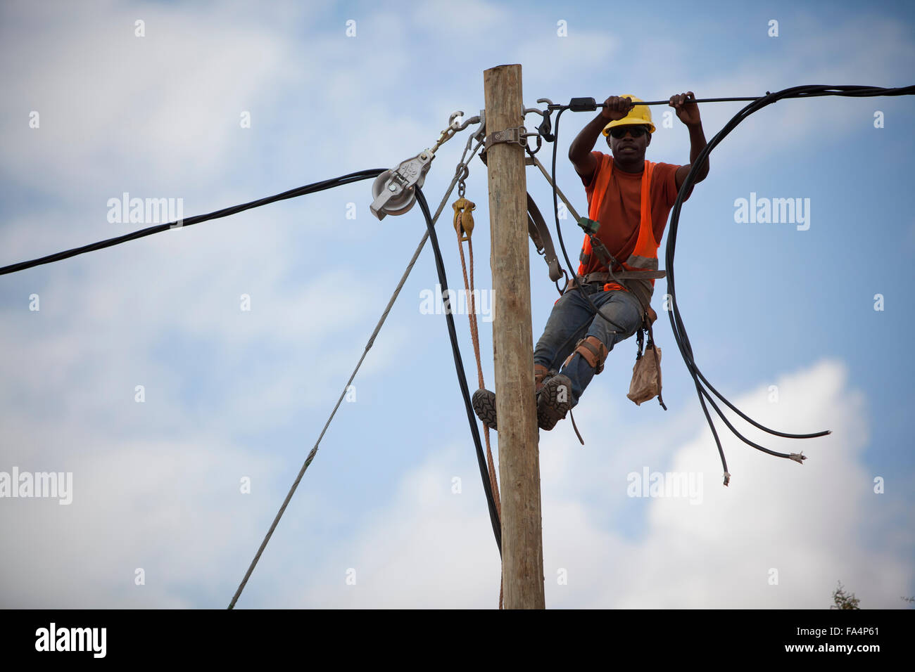 A worker strings new power cables in a rural village near Dodoma ...