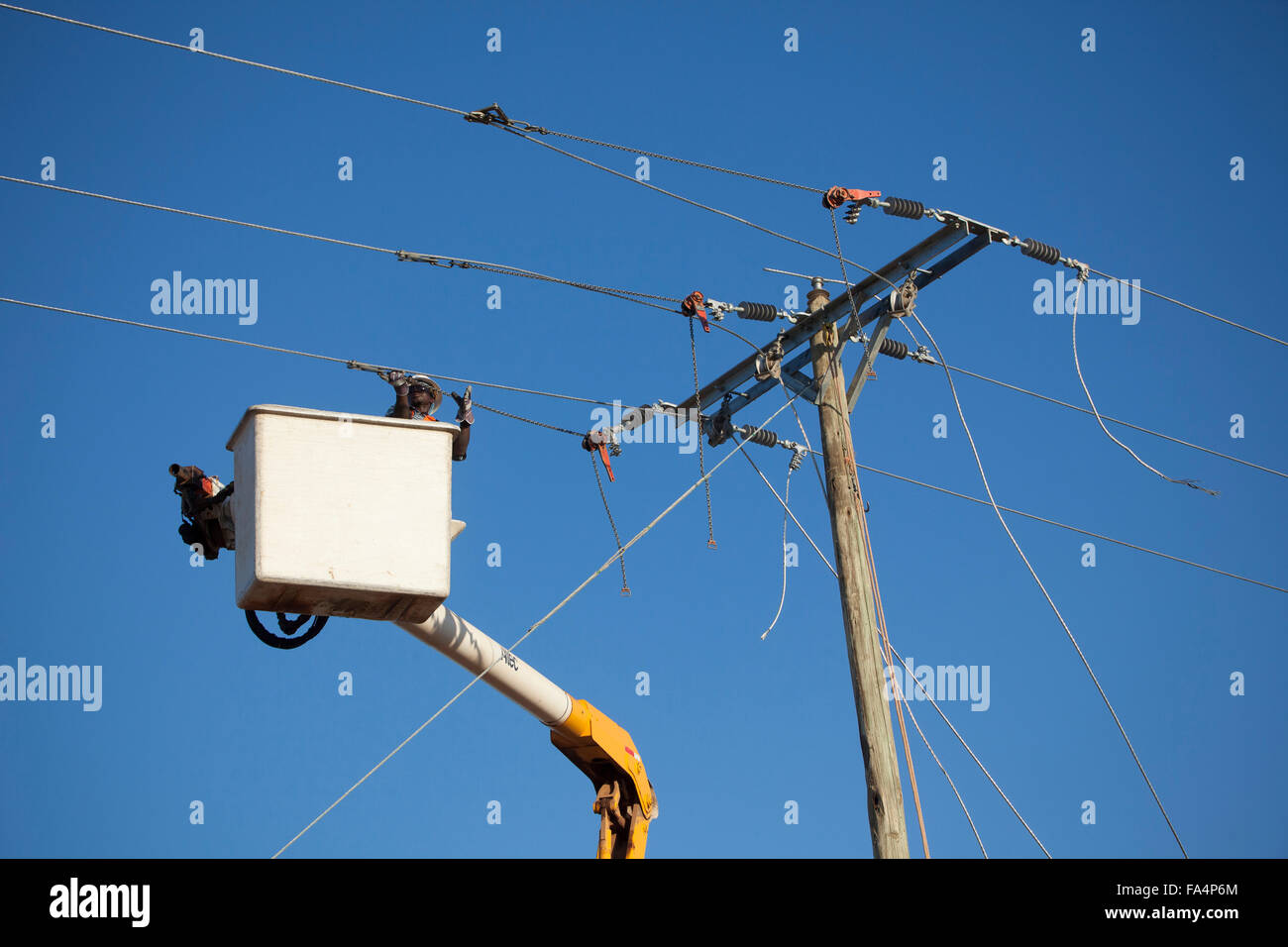 A worker strings new power cables in a rural village near Dodoma ...