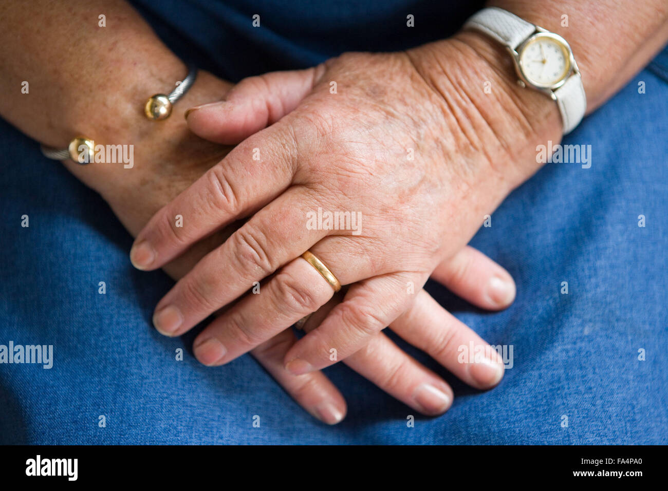 Older persons with hands on their lap Stock Photo - Alamy