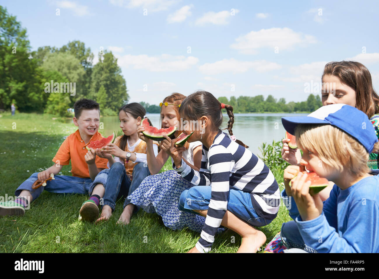 Children enjoying slices of watermelon at picnic, Munich, Bavaria ...