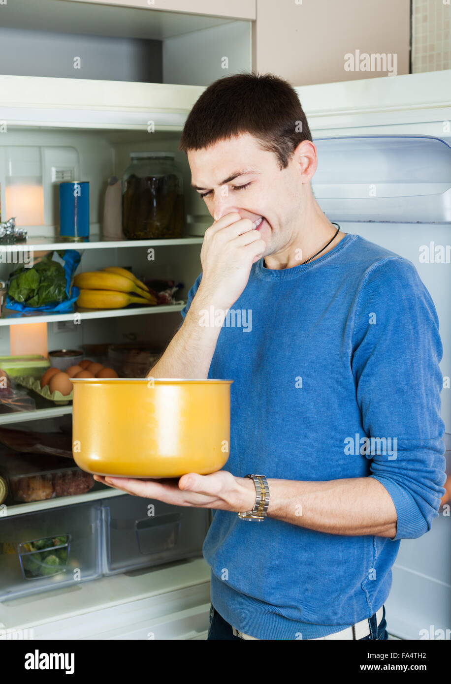 Hungry man holding his nose because of bad smell from food near ...