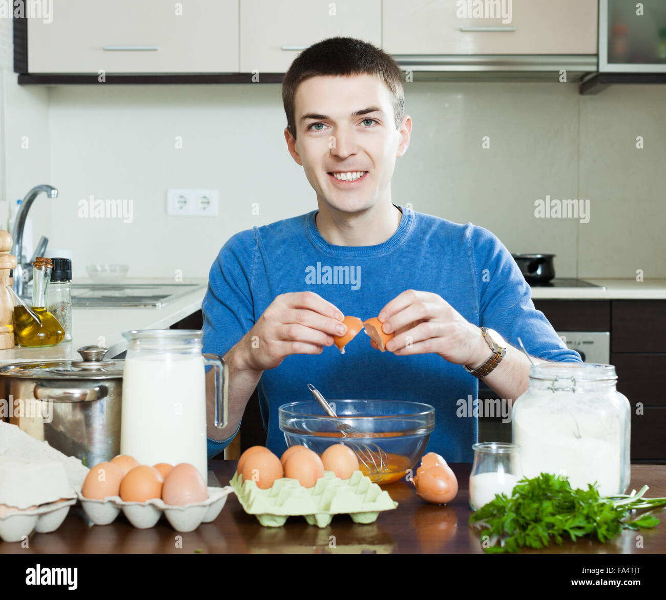 Guy cooking scrambled eggs in home Stock Photo - Alamy