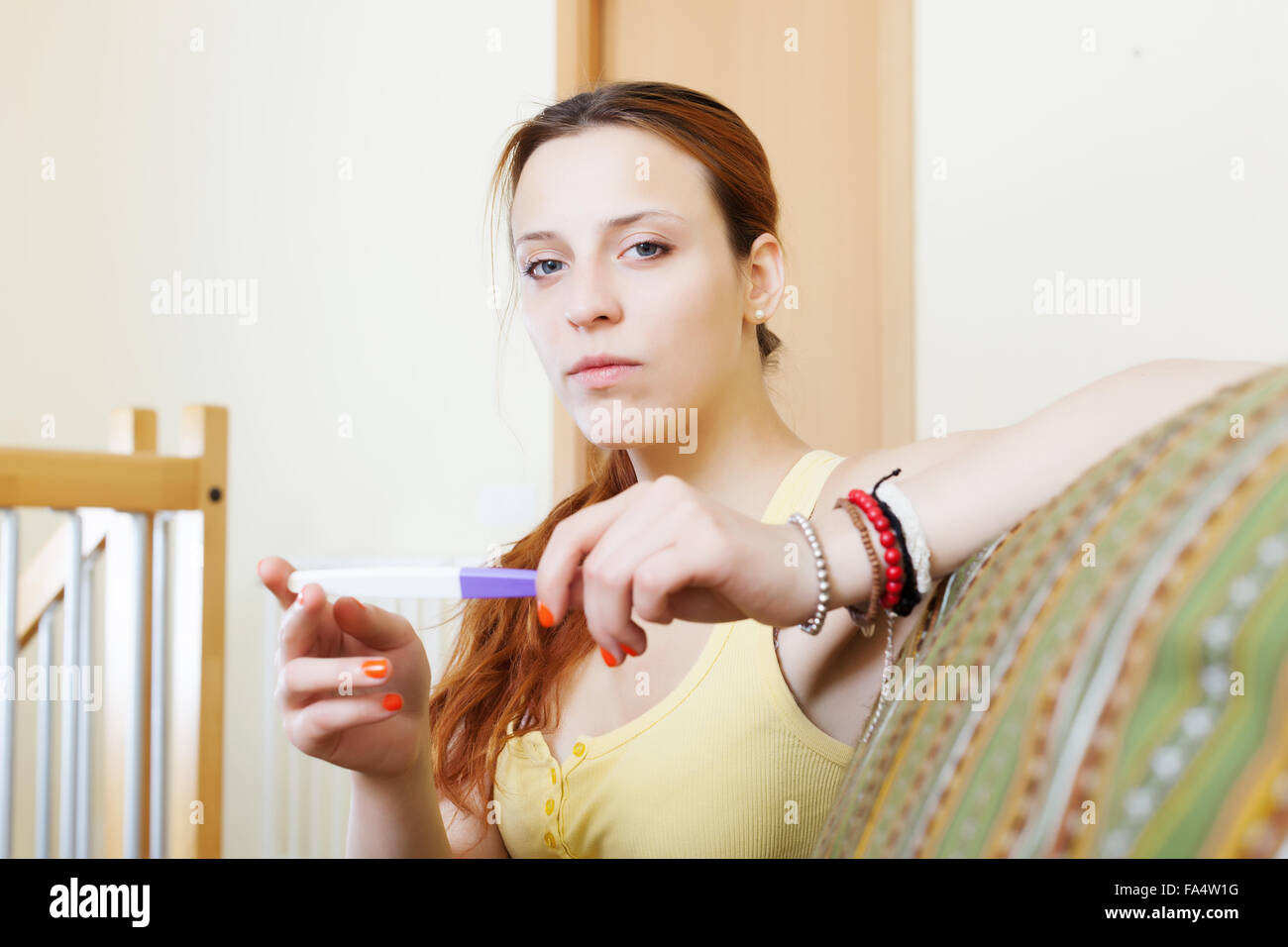 serious girl with pregnancy test at home Stock Photo - Alamy