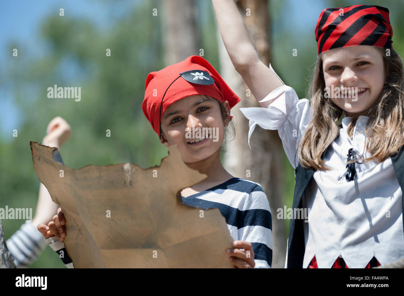 Portrait of girls holding treasure map in adventure playground, Bavaria ...