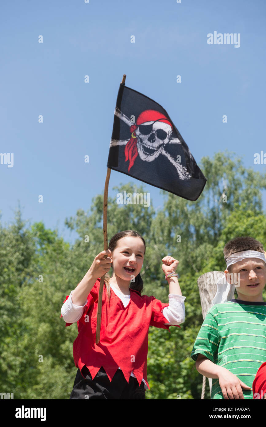 Girl holding pirate flag with her friend in adventure playground ...