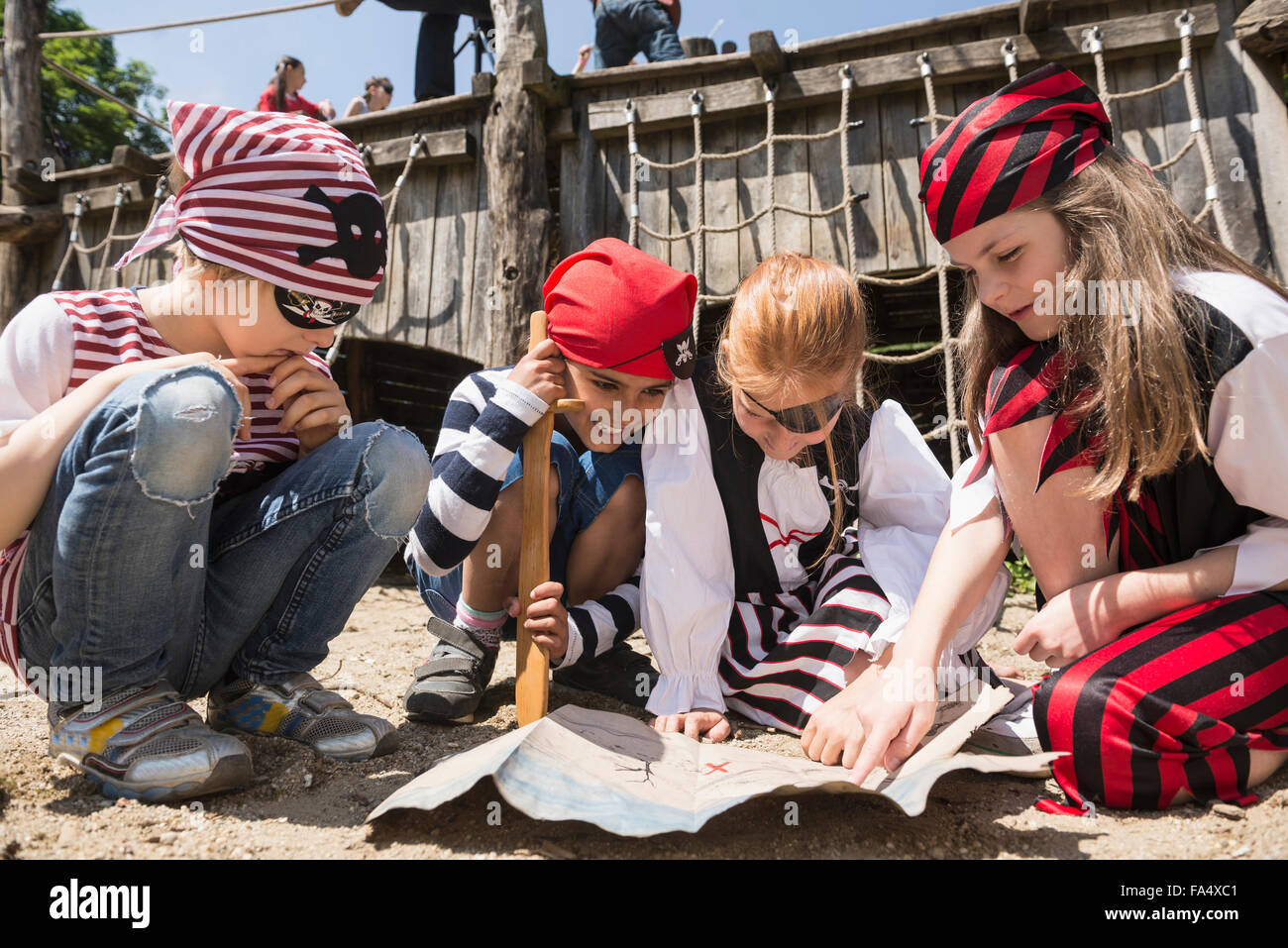 Girls examining a treasure map in a adventure playground, Bavaria ...
