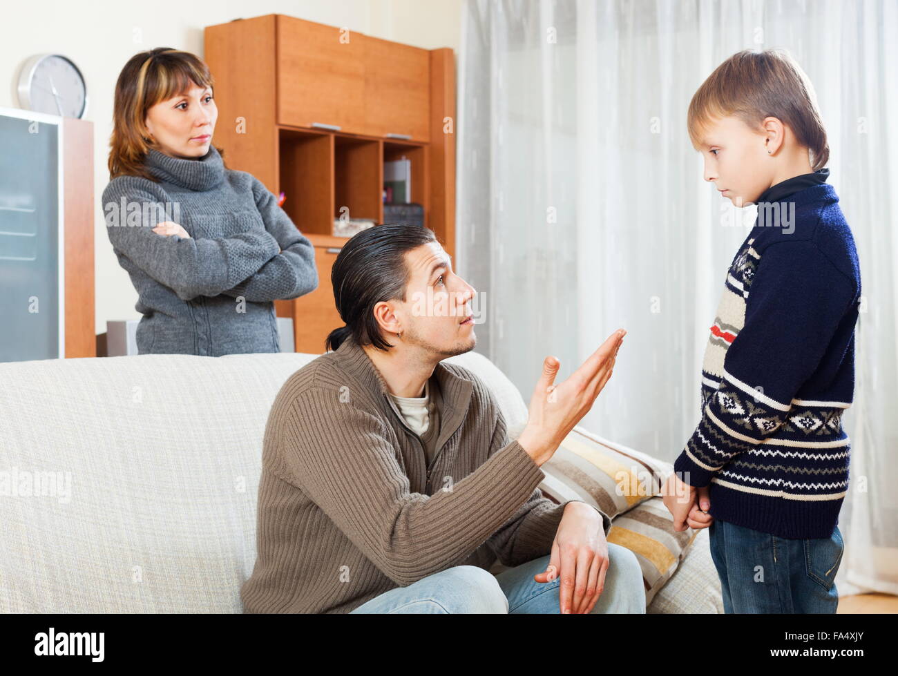 Serious parents berating their teenage son at home Stock Photo - Alamy