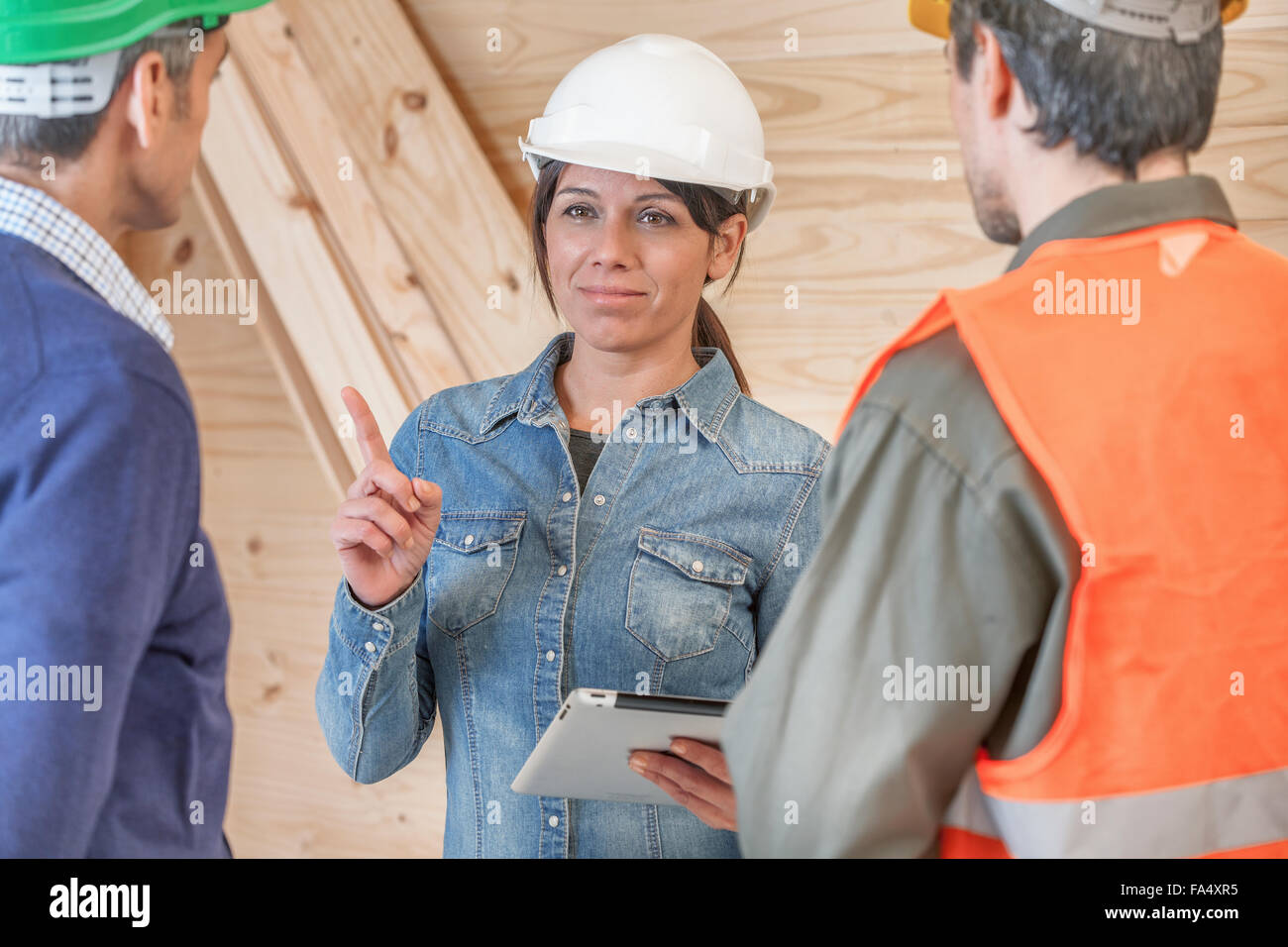 Construction crew listening to female supervisor Stock Photo - Alamy