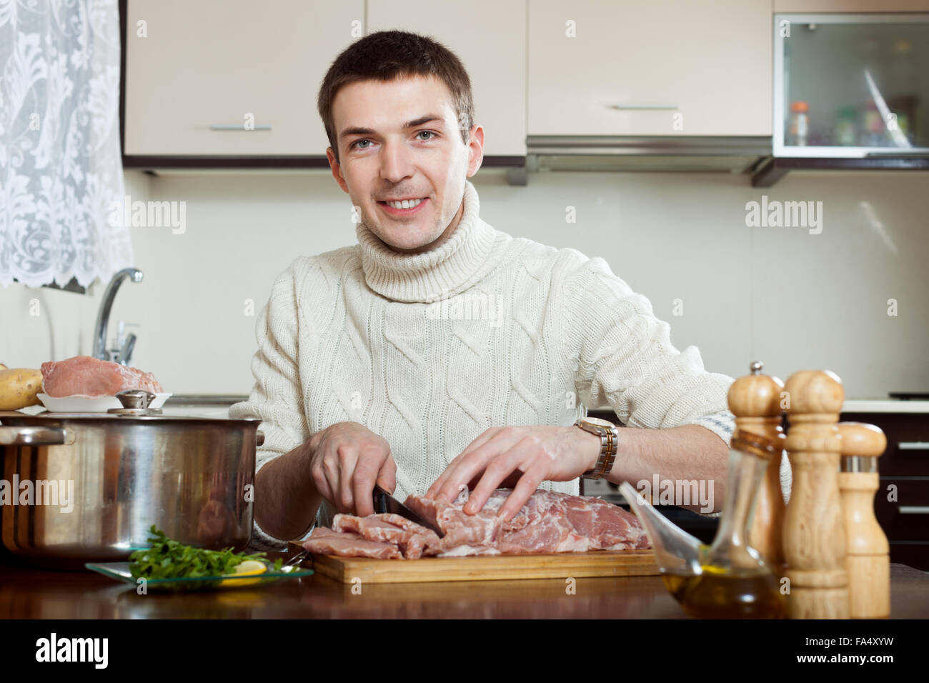 Ordinary guy cooking french-style meat. Hands cutting veal Stock Photo ...