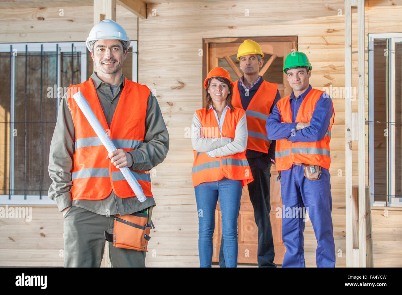 4 person construction crew standing in front of house Stock Photo - Alamy