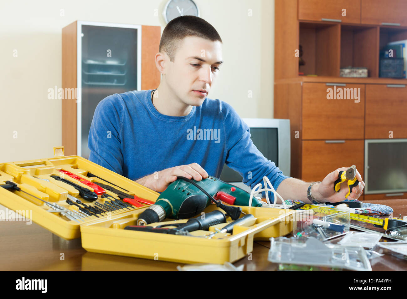 Man doing something with working tools in home Stock Photo - Alamy