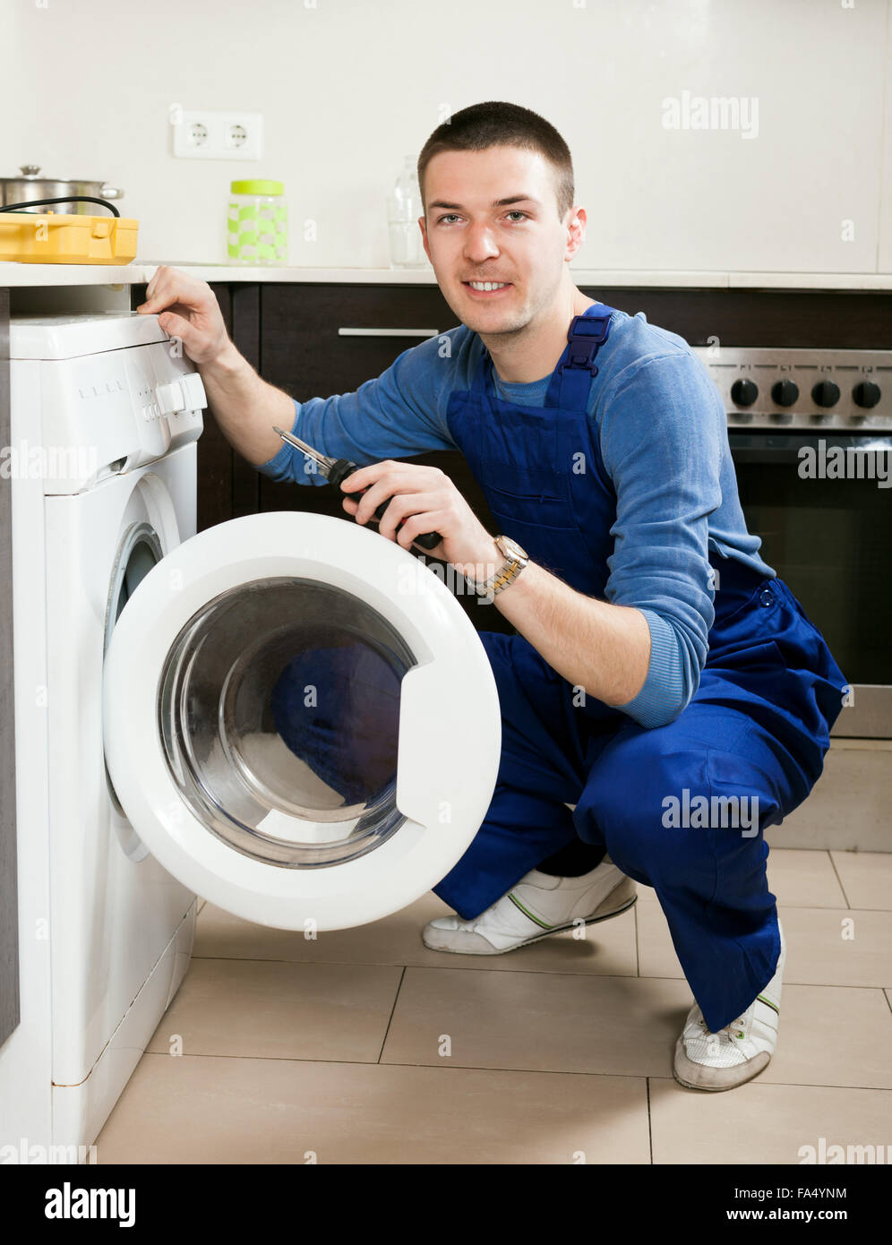 Handyman fixing washing machine hi-res stock photography and images - Alamy