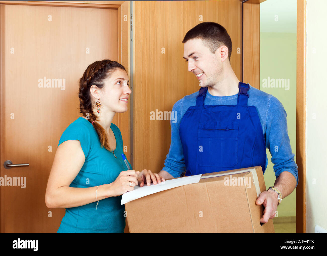 Postman in uniform delivered a parcel to woman at home Stock Photo - Alamy